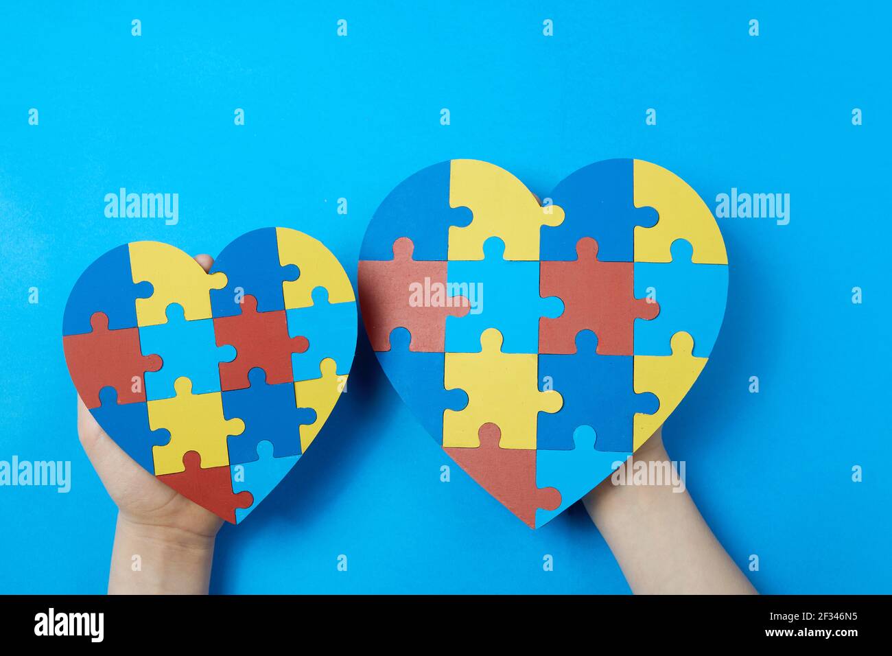 Autistic kid hands holding jigsaw puzzle heart shape. Autism spectrum ...