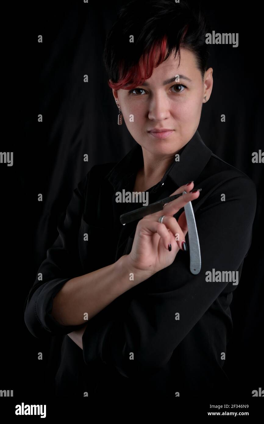 Half length portrait of young adult barber woman on black background ...
