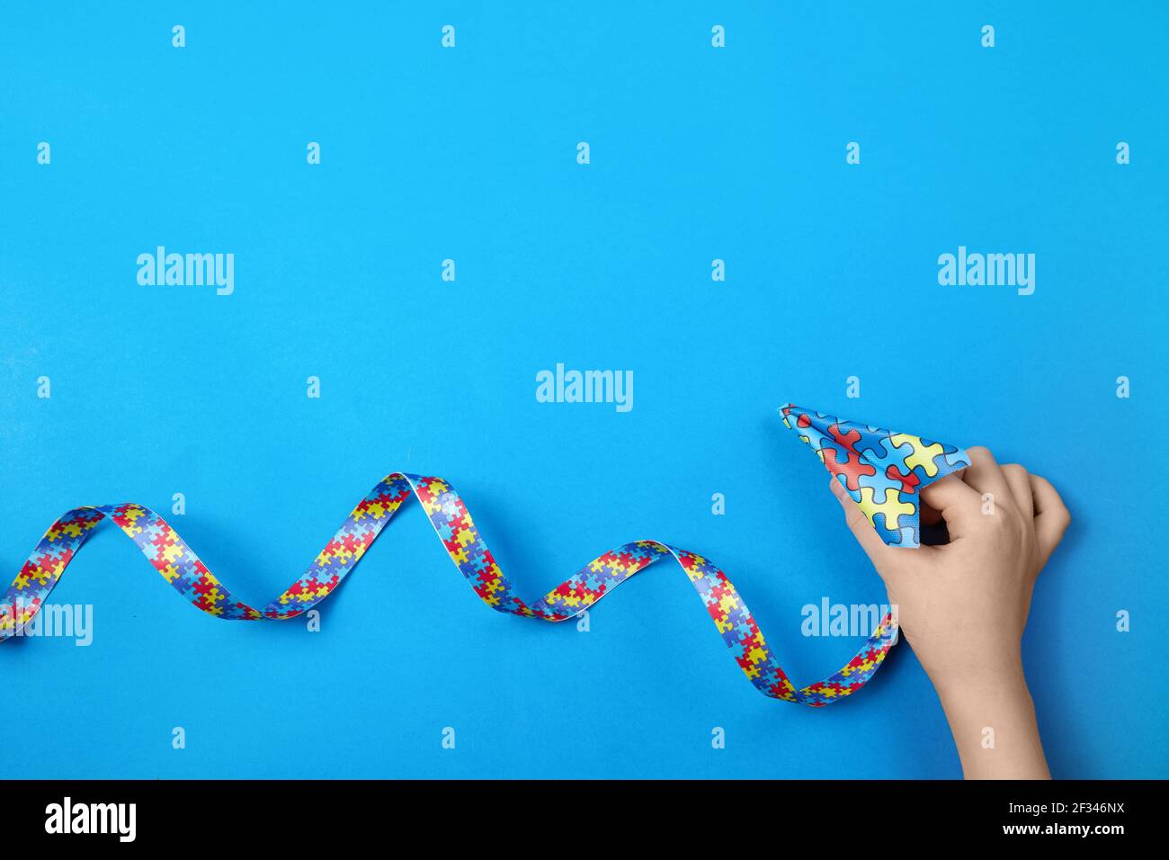 Autism awareness. Aitistic child hand holding paper plane in origami ...