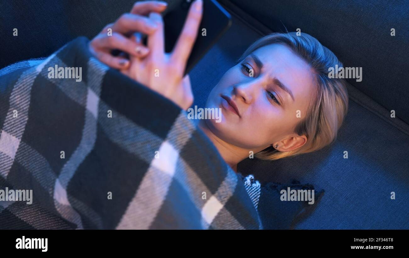 Young lonely woman setting up dating profile using the smartphone ...