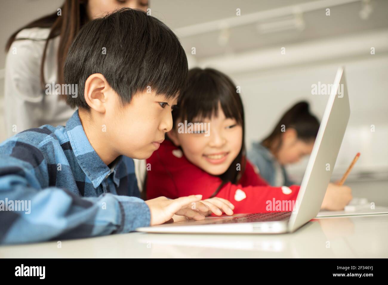 ICT in Education - Elementary School Students and Teacher Looking at PC ...