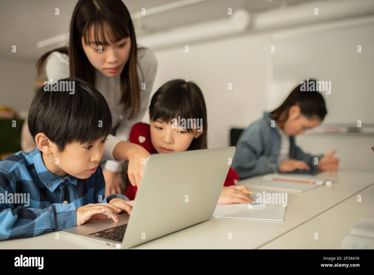 ICT in Education - Elementary School Students and Teacher Looking at PC ...