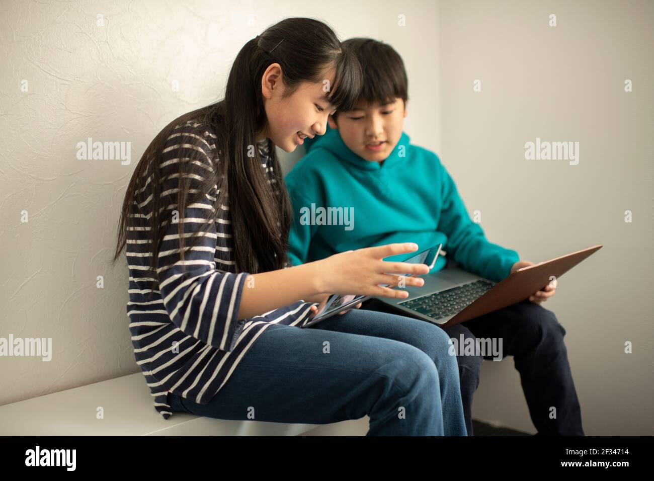 ICT in Education - Boy and Girl Utilizing Digital Devices Stock Photo ...