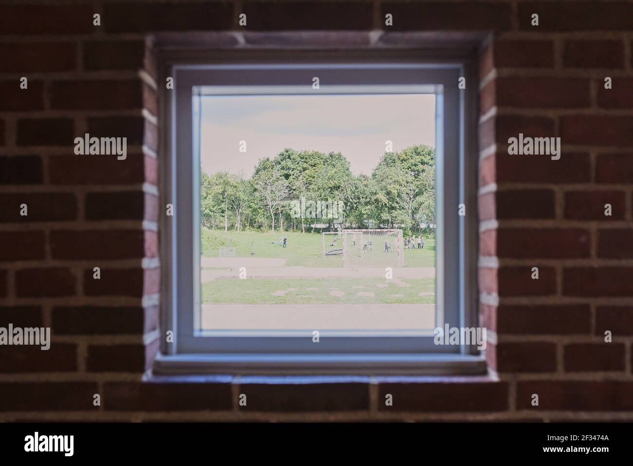 a window showing children playing soccer on field Stock Photo - Alamy