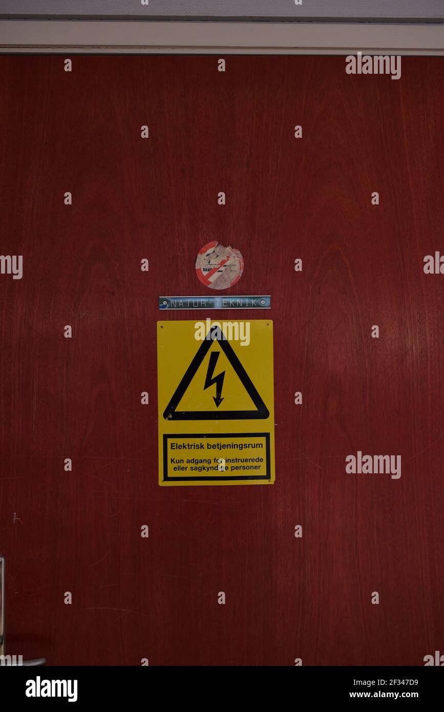 yellow warning sign about electricity on door Stock Photo - Alamy