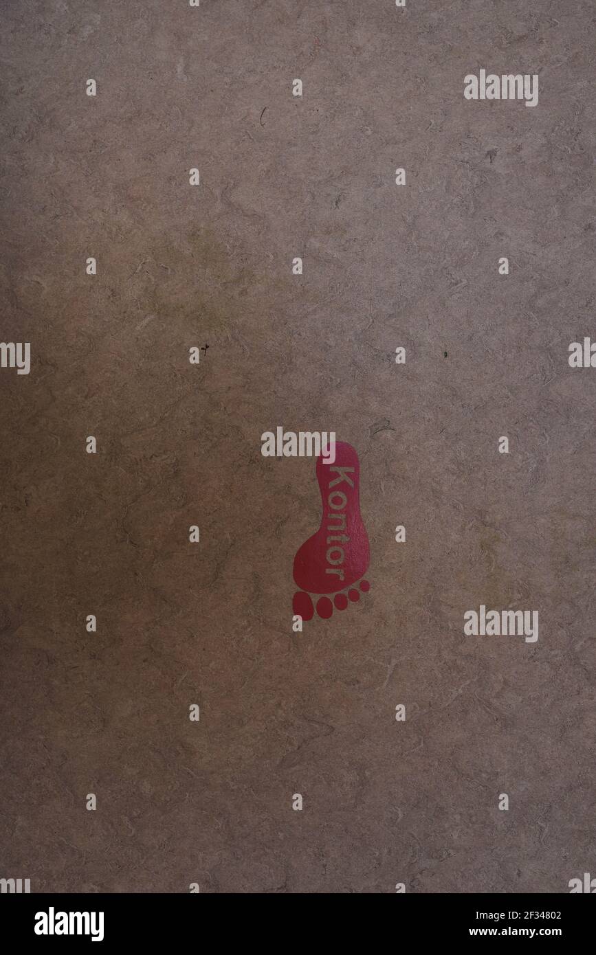 red footprint sticker on floor giving direction to office at a school ...