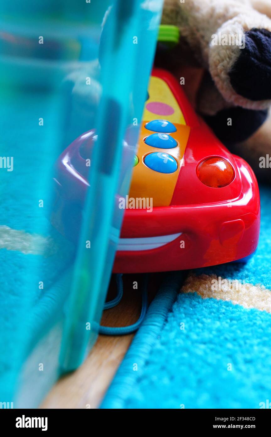 Red plastic toy car behind a blue plastic box Stock Photo - Alamy