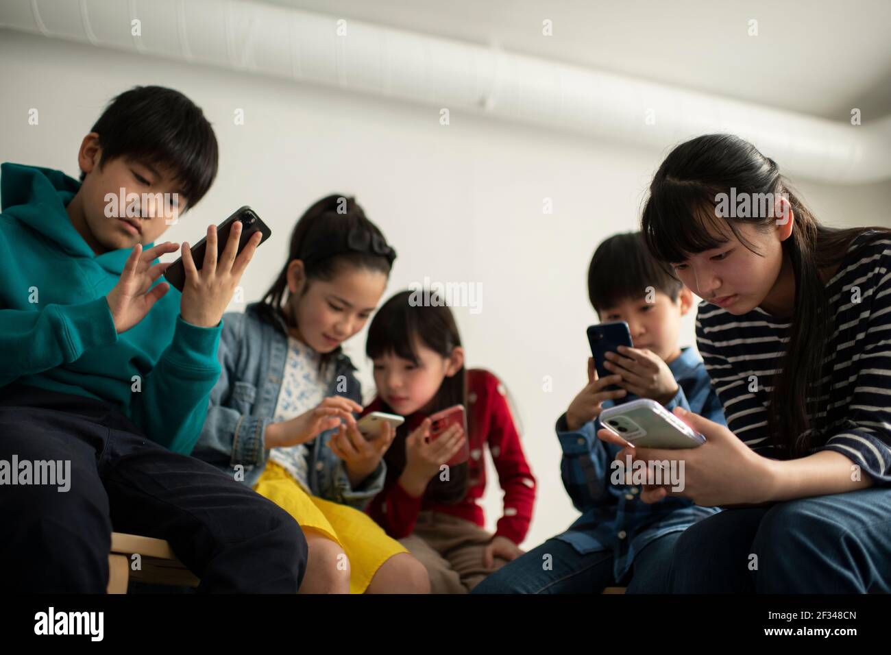 Children Obsessed with Smartphone Stock Photo - Alamy