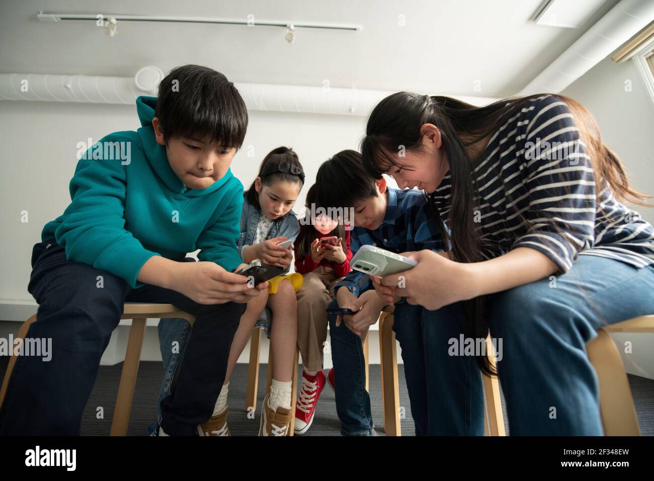Children Obsessed with Smartphone Stock Photo - Alamy