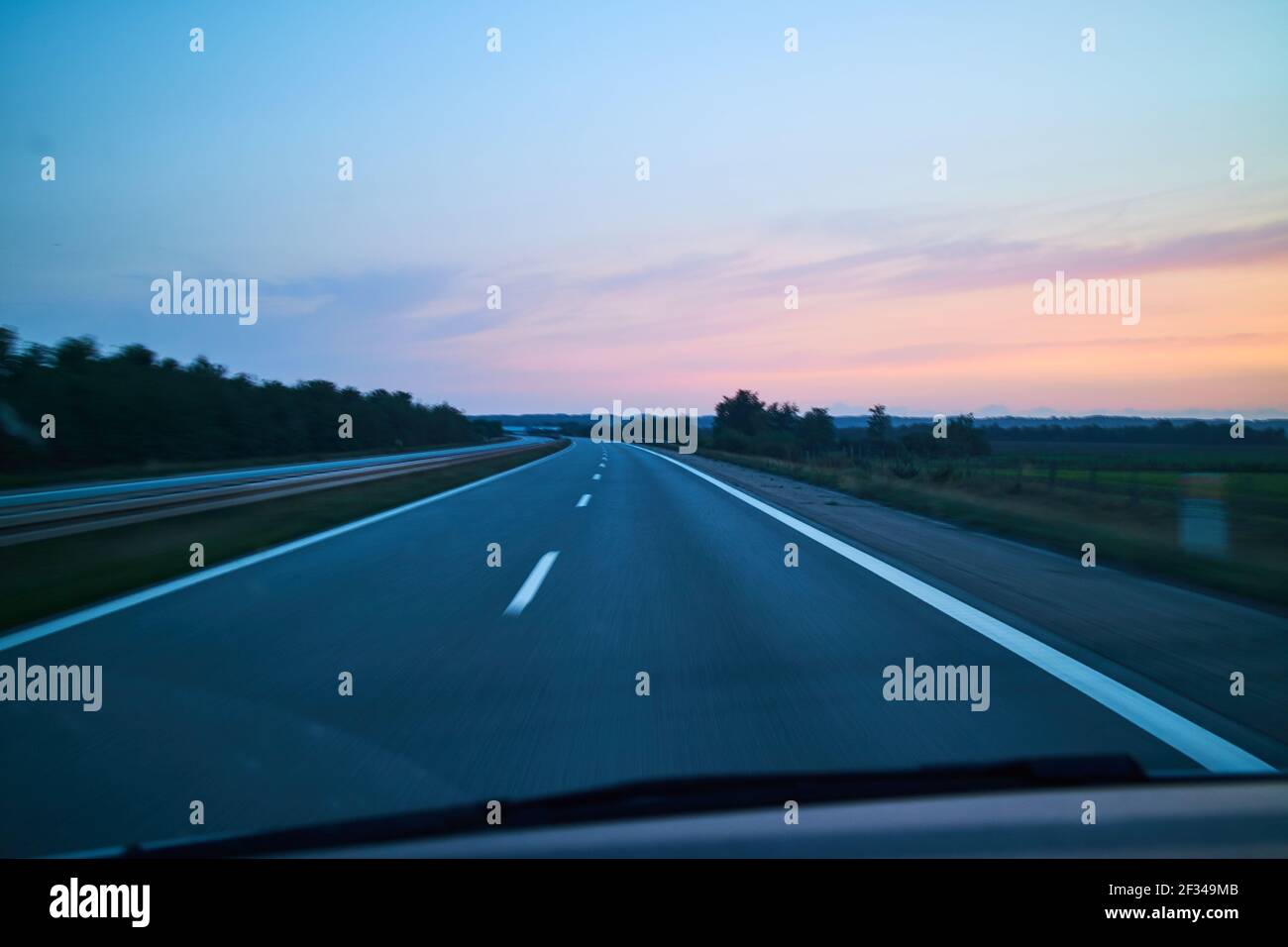 a car ride in purple sunset on a highway Stock Photo - Alamy