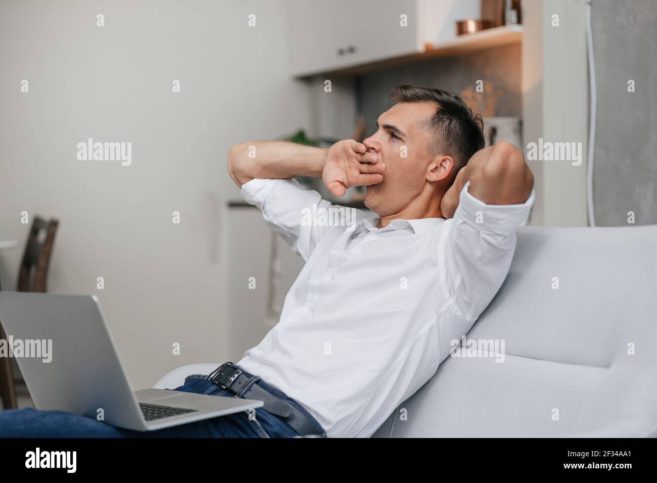 tired young man looking at his laptop screen Stock Photo - Alamy