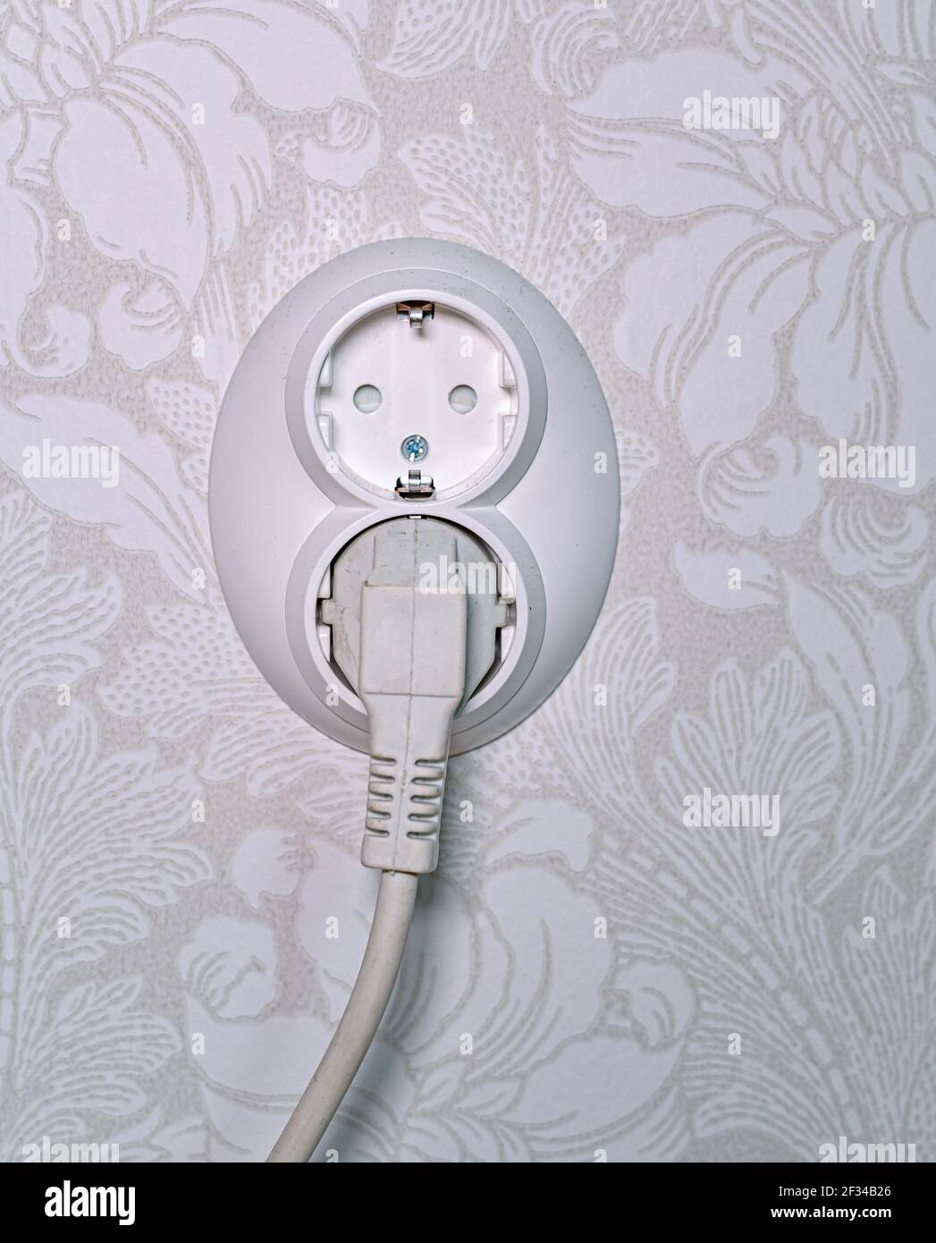 white plastic wall socket on wallpaper with one plug Stock Photo - Alamy