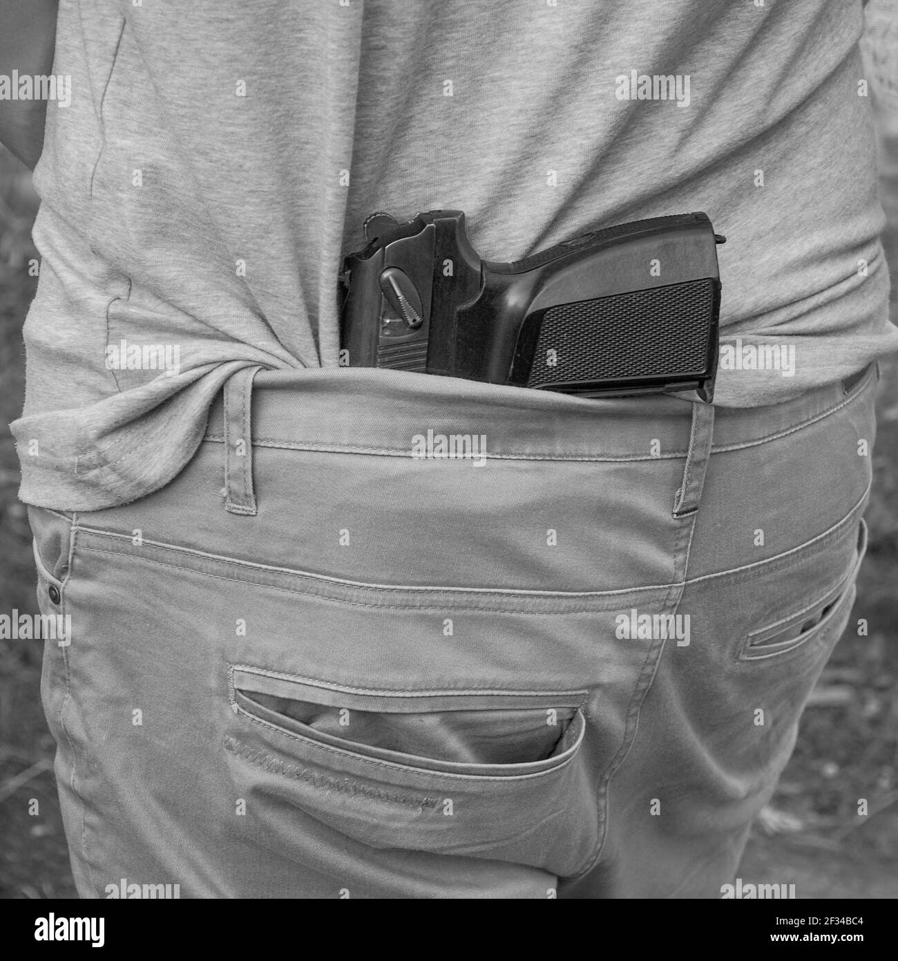 The gun is hidden behind the man's back Stock Photo - Alamy