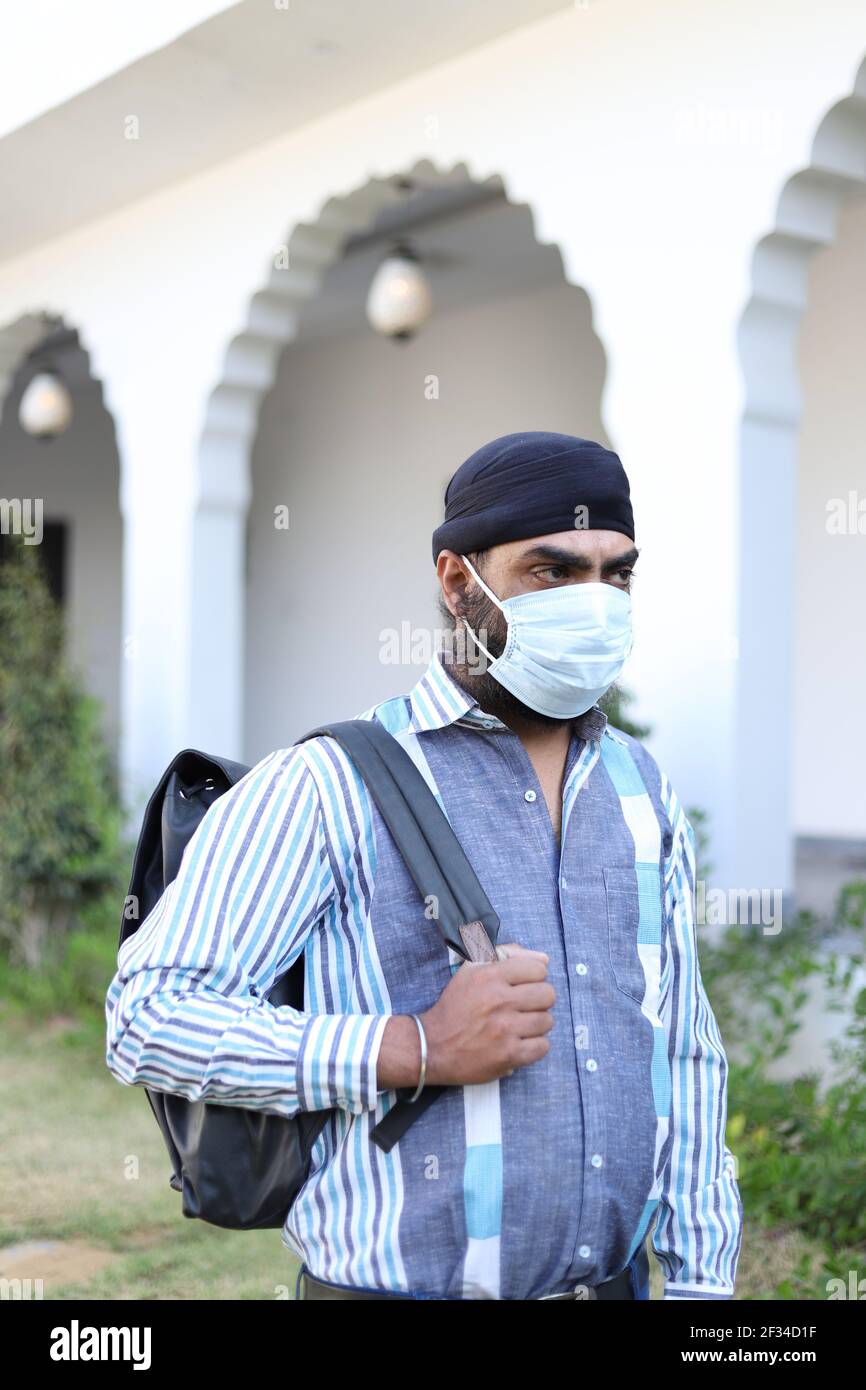 A middle-aged Indian man with a turban, wearing a mask - new normal ...