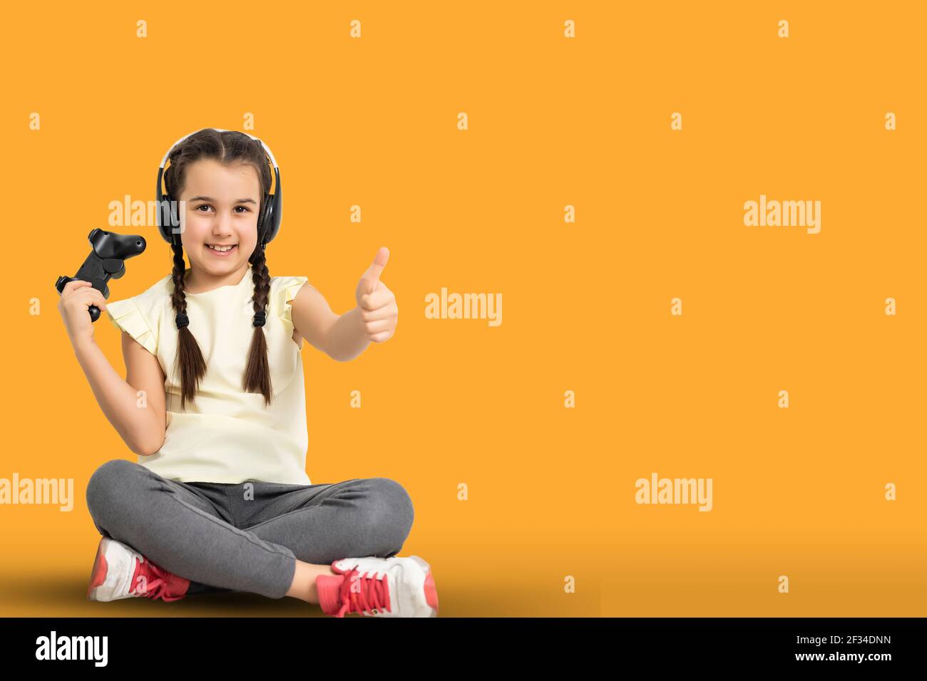 Child using video game controller. Isolated on yellow background Stock ...
