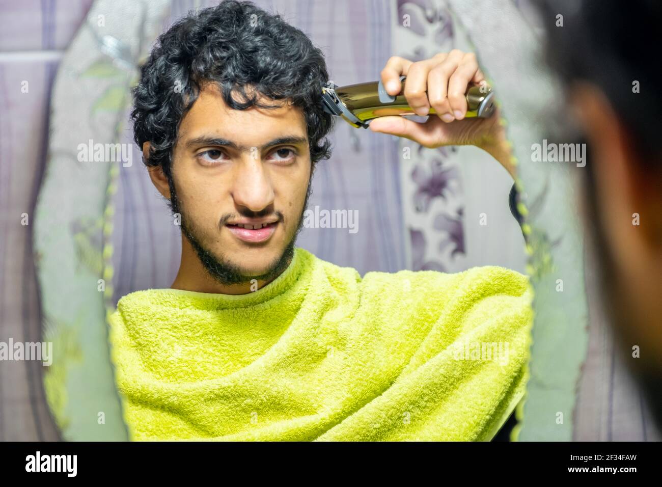 Arabic muslim man cutting his own hair by himself Stock Photo - Alamy