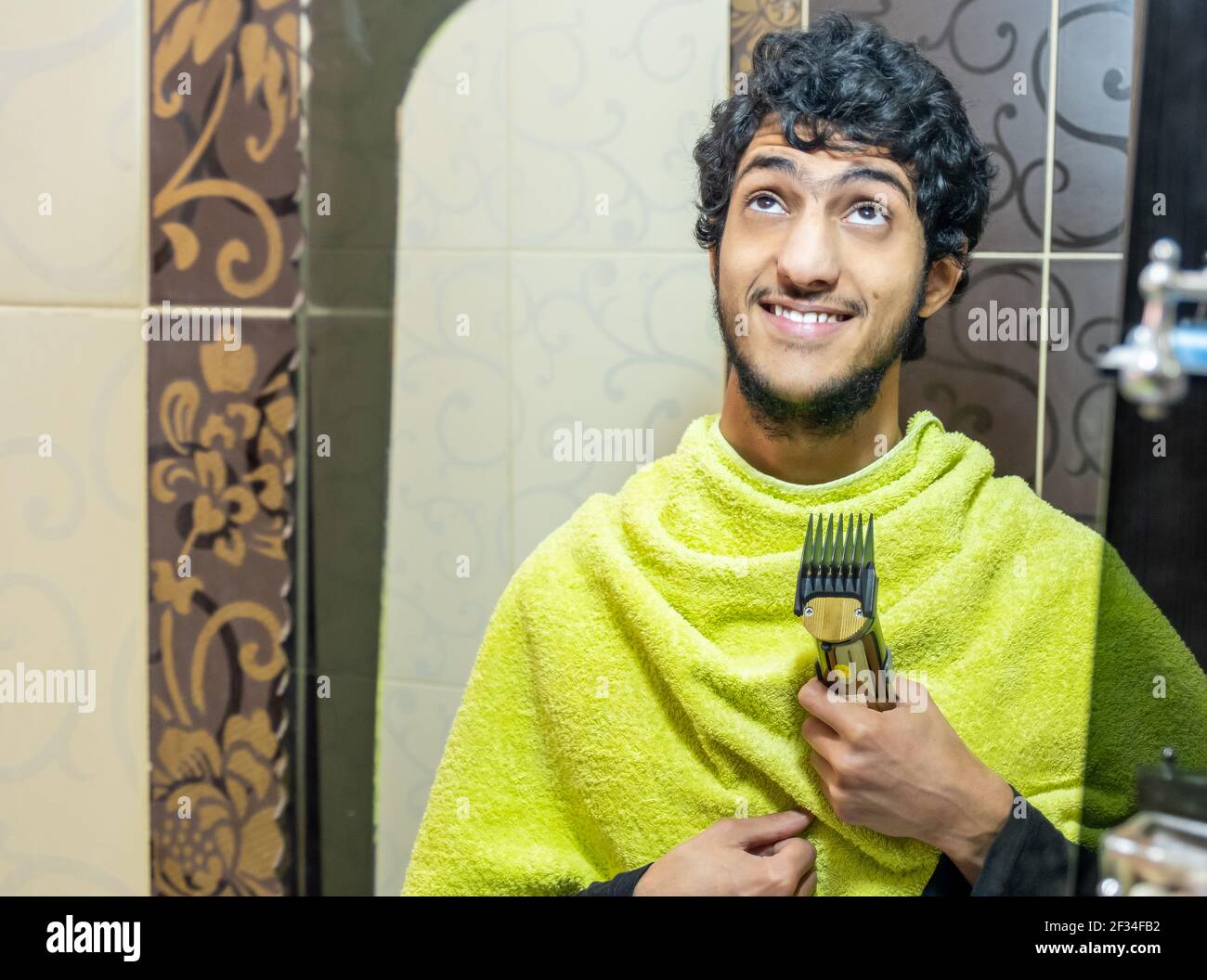 Arabic muslim man cutting his own hair by himself Stock Photo - Alamy