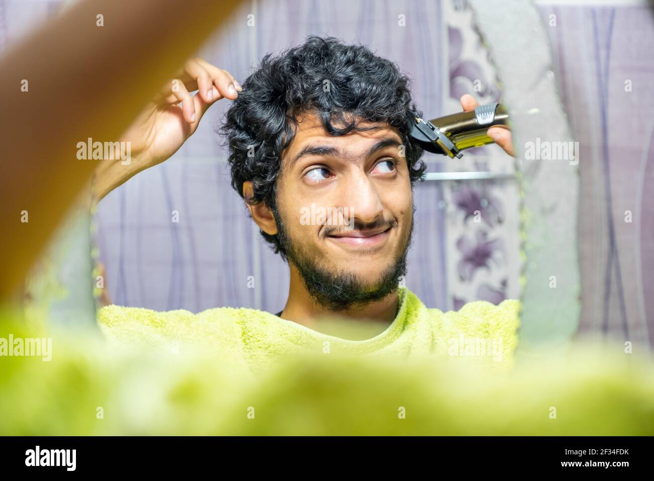 Arabic muslim man cutting his own hair by himself Stock Photo - Alamy