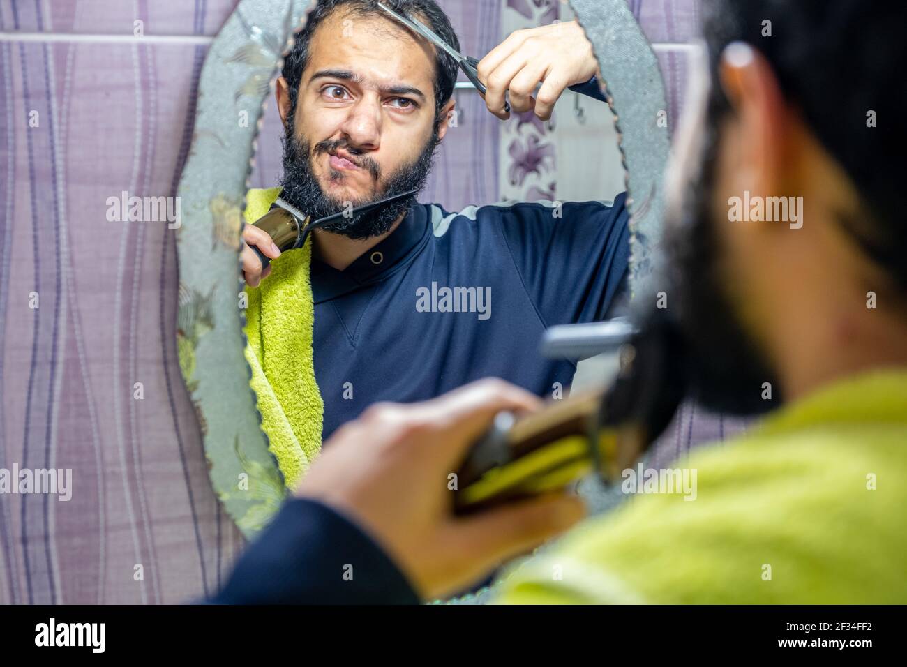 Arabic muslim man cutting his own hair by himself Stock Photo - Alamy