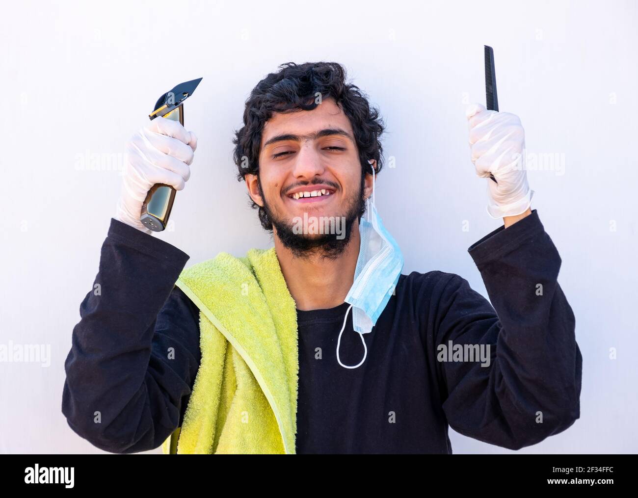 Arabic muslim guy wearing mask and holding barber equipment Stock Photo ...