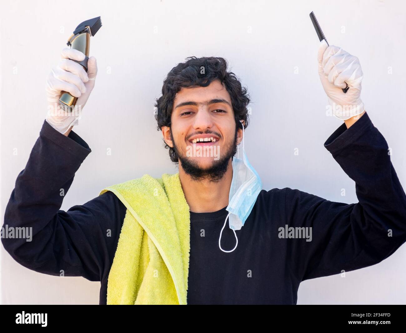 Arabic muslim guy wearing mask and holding barber equipment Stock Photo ...
