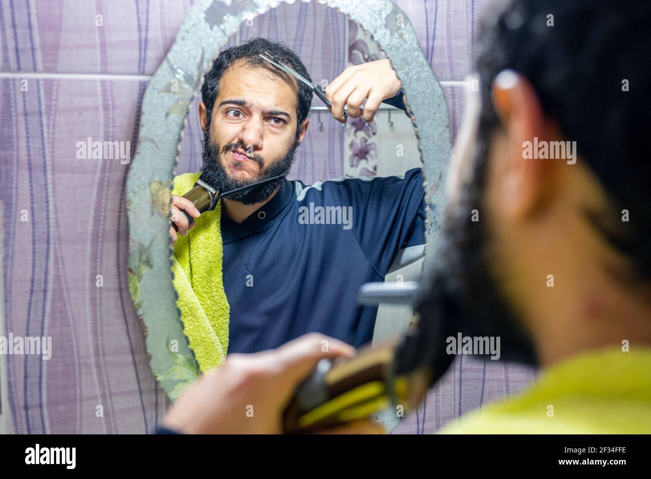 Arabic muslim man cutting his own hair by himself Stock Photo - Alamy
