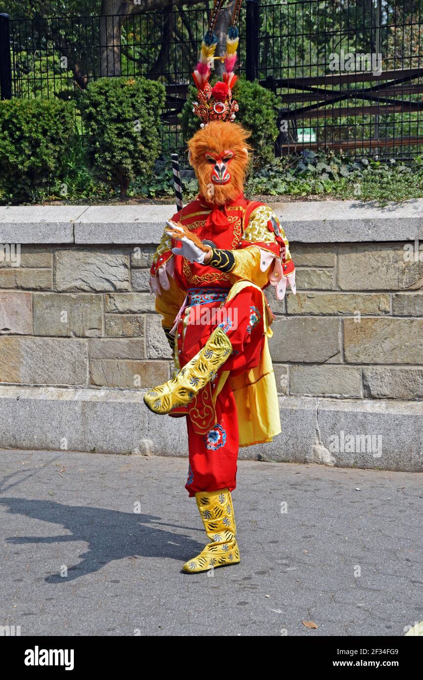 Photo of an Asian busker dressed in a colorful costume dancing for ...