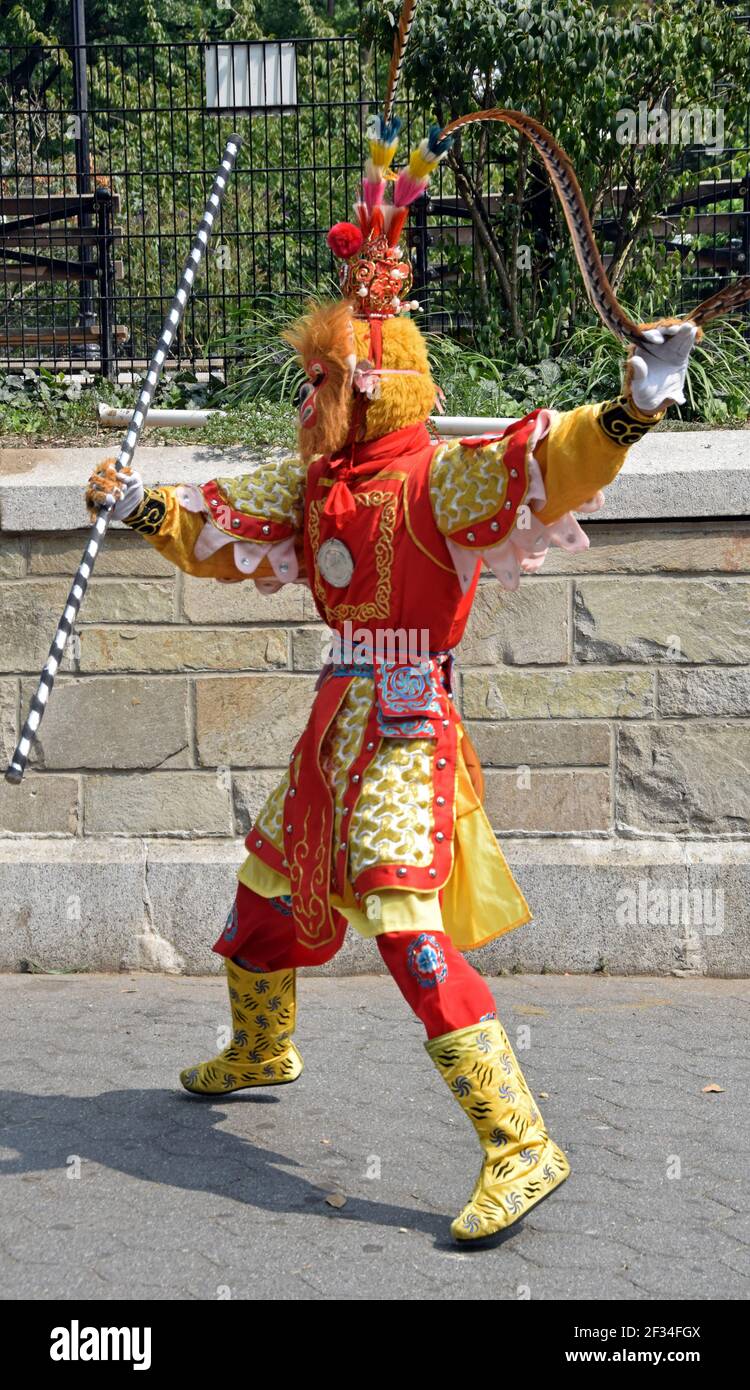 Photo of an Asian busker dressed in a colorful costume dancing for ...