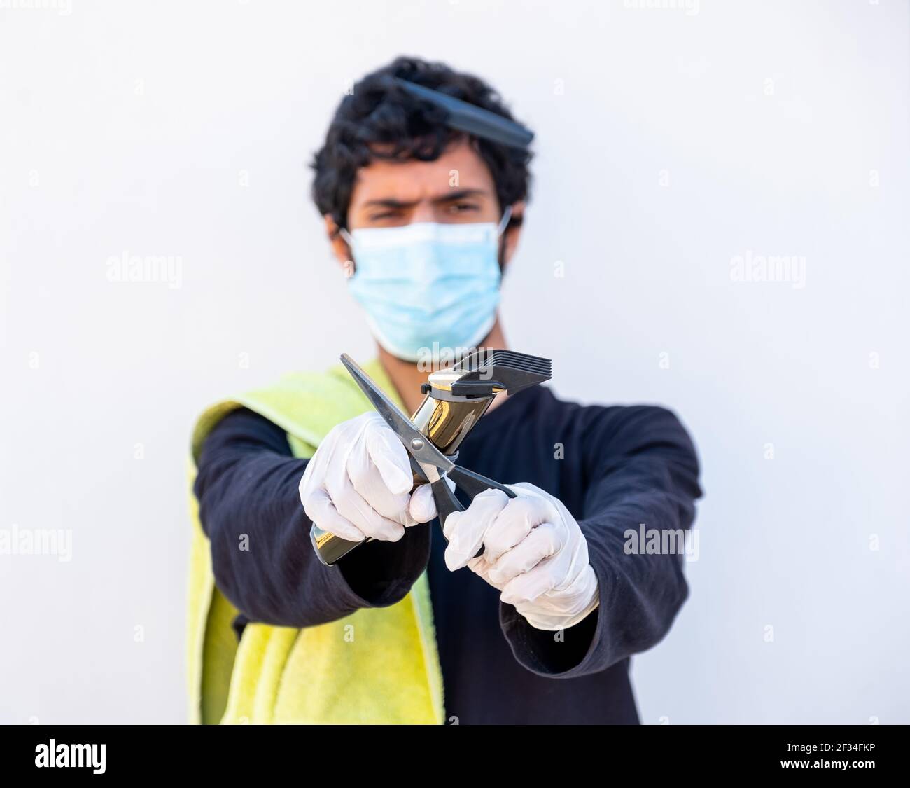 Arabic Muslim guy wearing mask and holding barber equipment Stock Photo ...