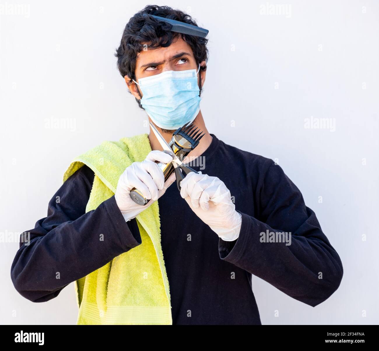 Arabic Muslim guy wearing mask and holding barber equipment Stock Photo ...