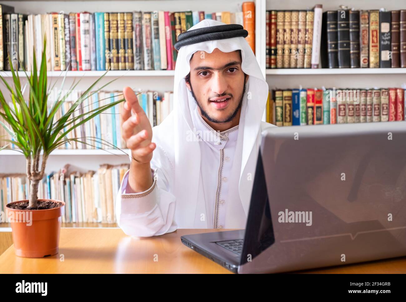 Arabic muslim man using his laptop to do seminars online Stock Photo ...