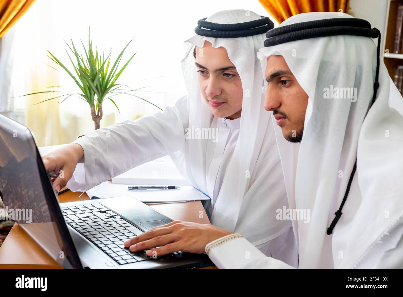 Two Arabic businessmen discussing business together Stock Photo - Alamy