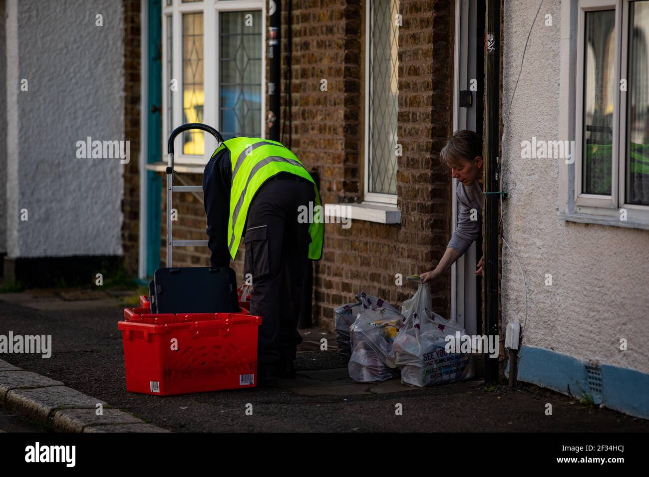A Ocado delivery driver dropping off food shopping outside a customer ...