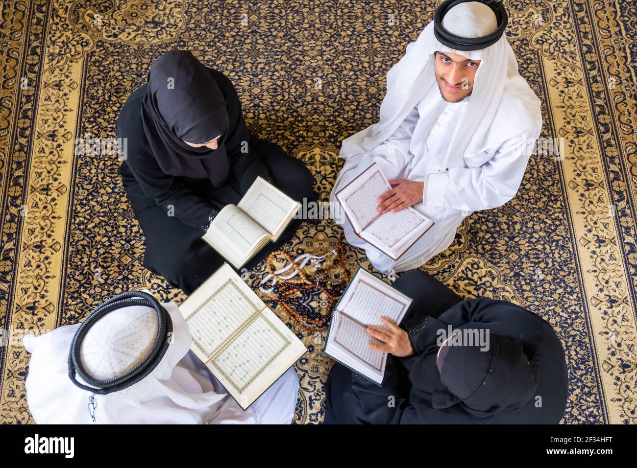 Top view of Muslim family members reading Quran together Stock Photo ...