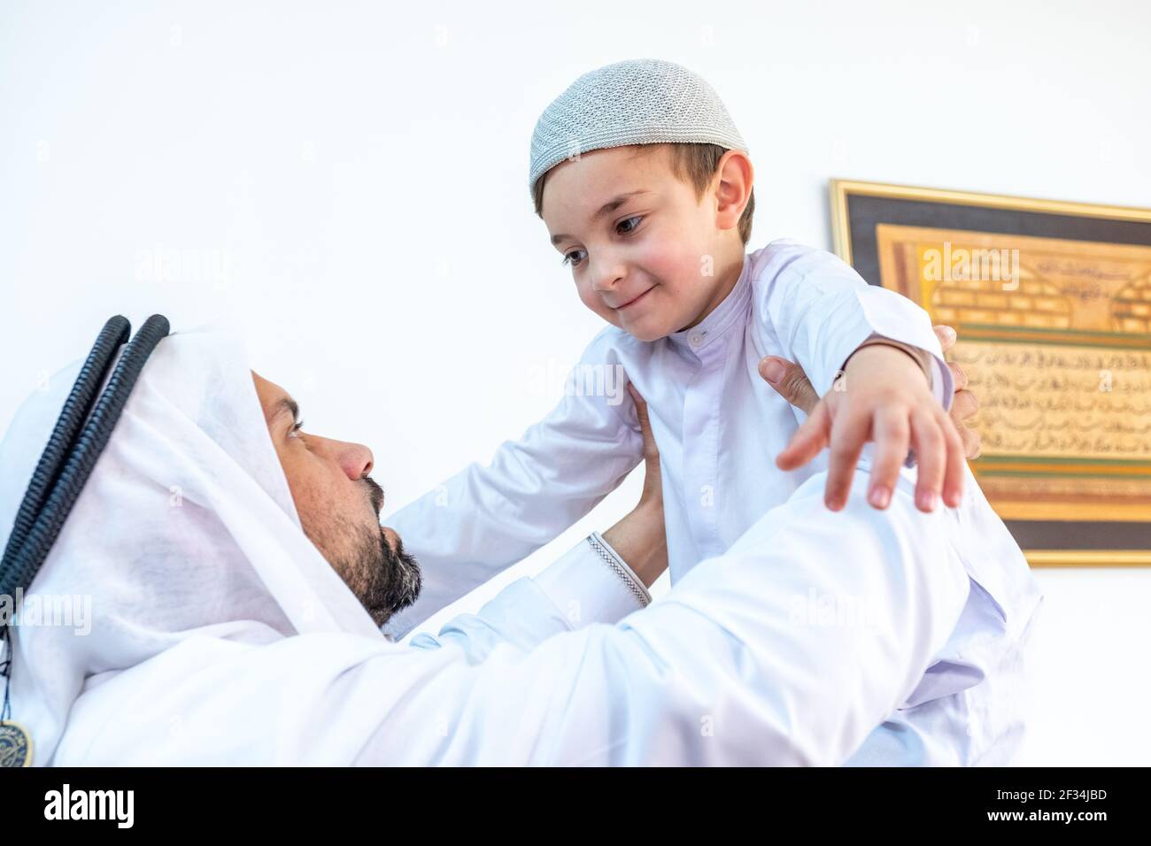 Arabic Muslim father holding his son high Stock Photo - Alamy