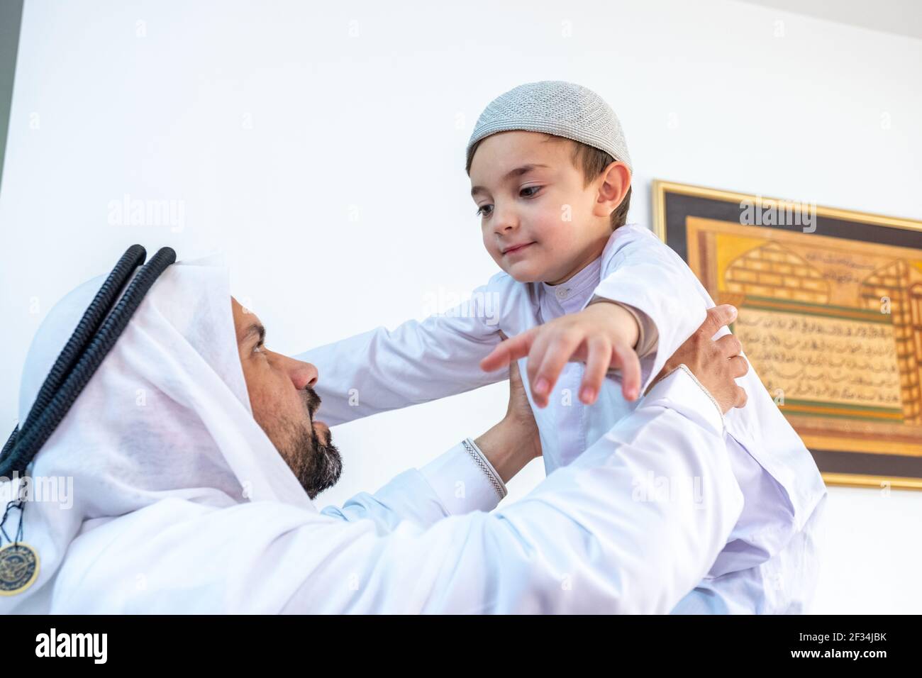 Arabic Muslim father holding his son high Stock Photo - Alamy