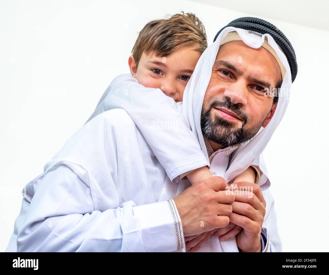 Happy Arabic Muslim father and his on his back Stock Photo - Alamy