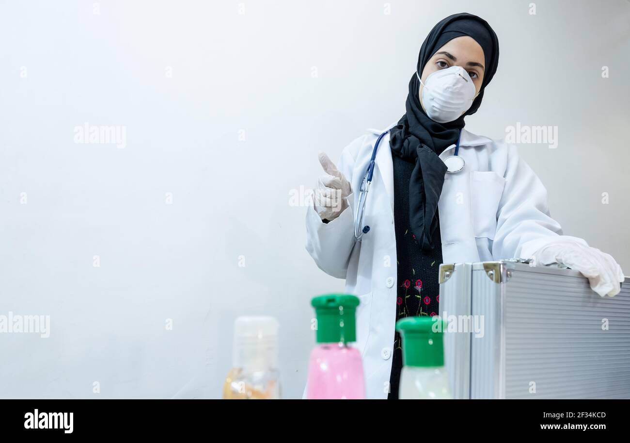 Arabic muslim doctor wearing mask and presenting hygiene and protection ...