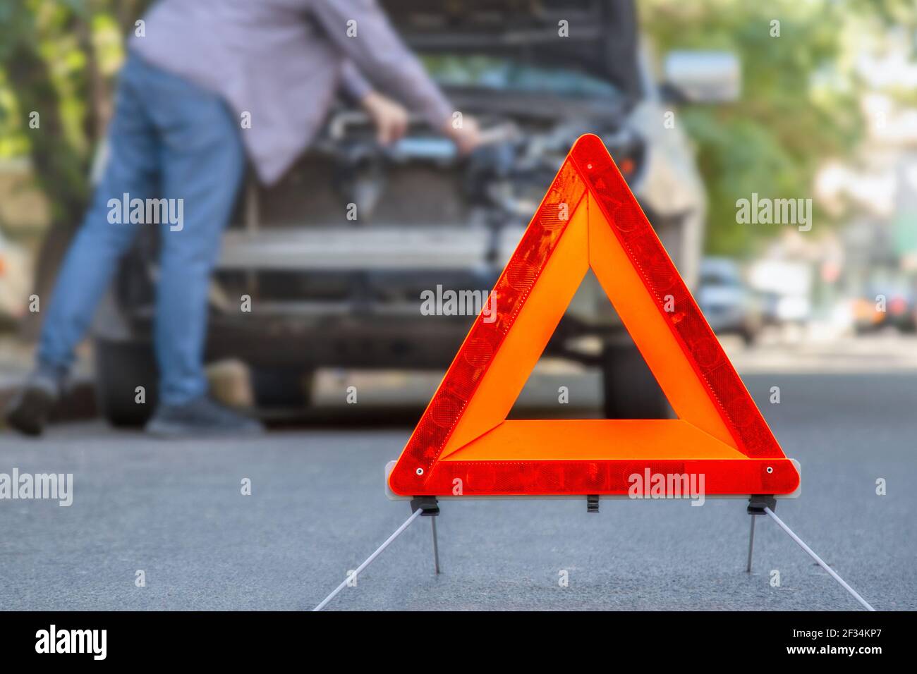 Red emergency stop triangle sign afore Destroyed car in car crash ...