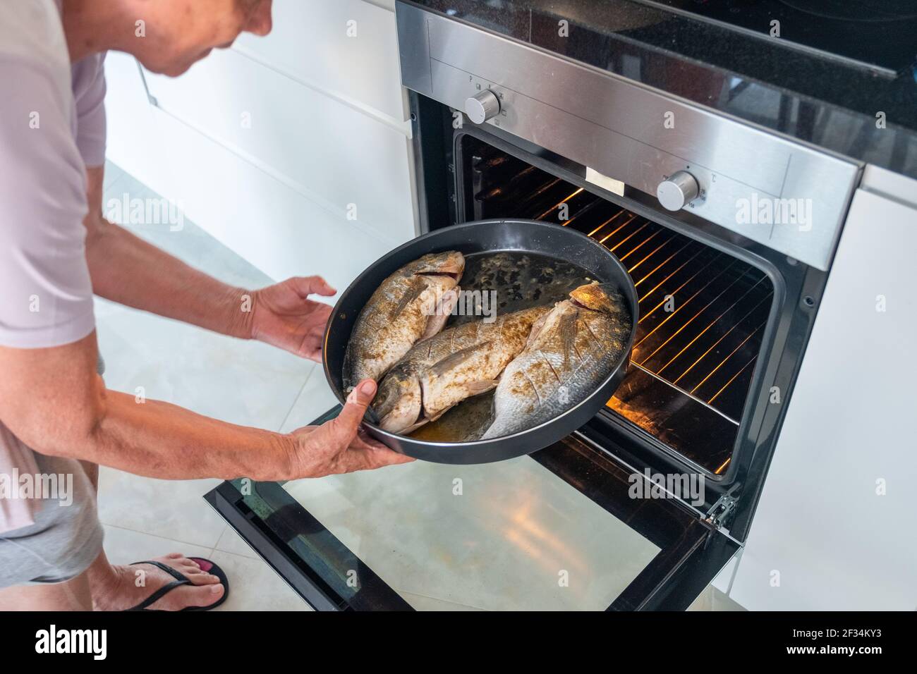 Tray of fishes is going into the oven to be cooked Stock Photo - Alamy