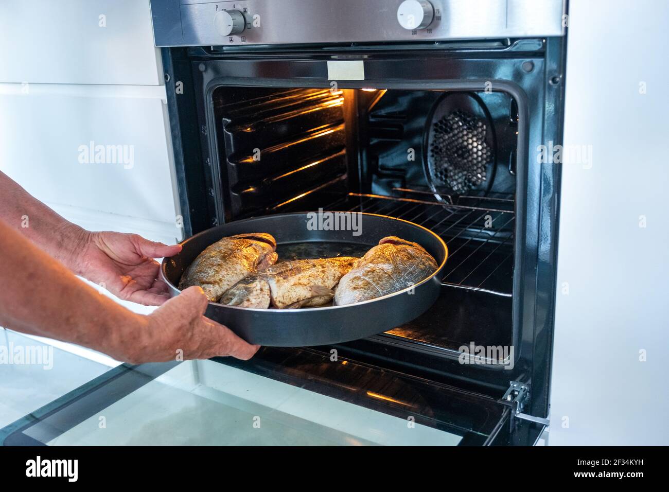Tray of fishes is going into the oven to be cooked Stock Photo - Alamy