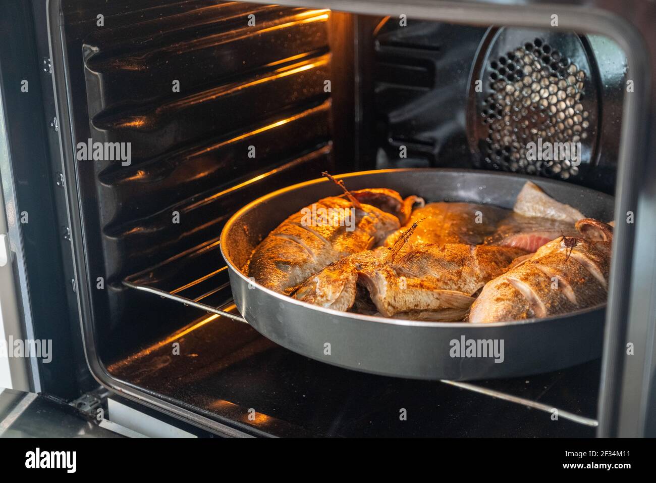Tray of fishes is going into the oven to be cooked Stock Photo - Alamy