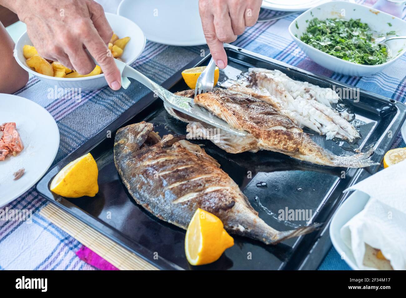 Family gathering to eat fish together Stock Photo - Alamy