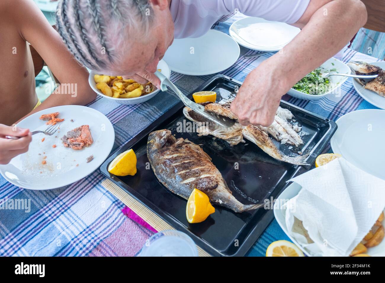 Family gathering to eat fish together Stock Photo - Alamy