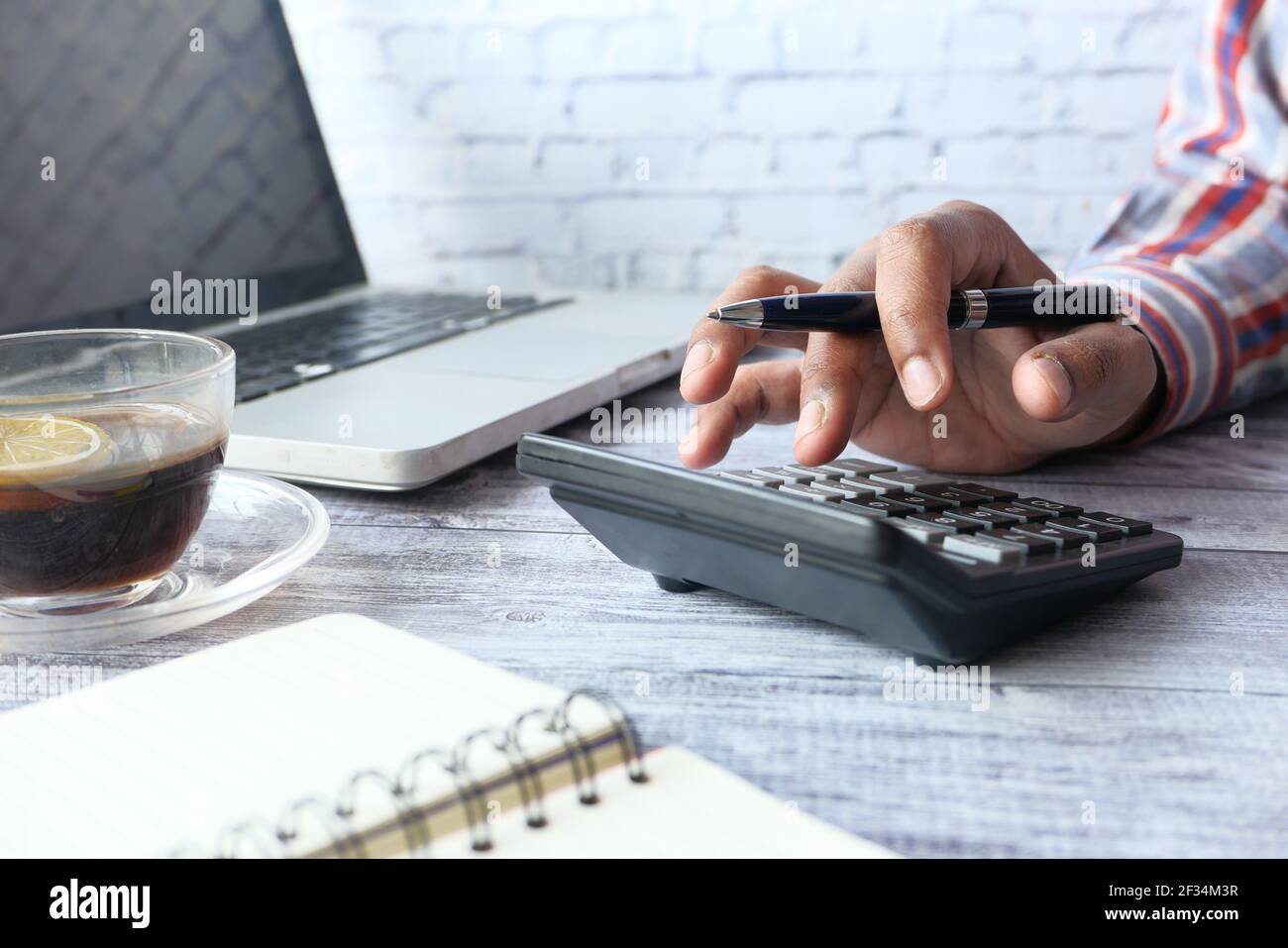 man hand using calculator and laptop on office desk Stock Photo - Alamy