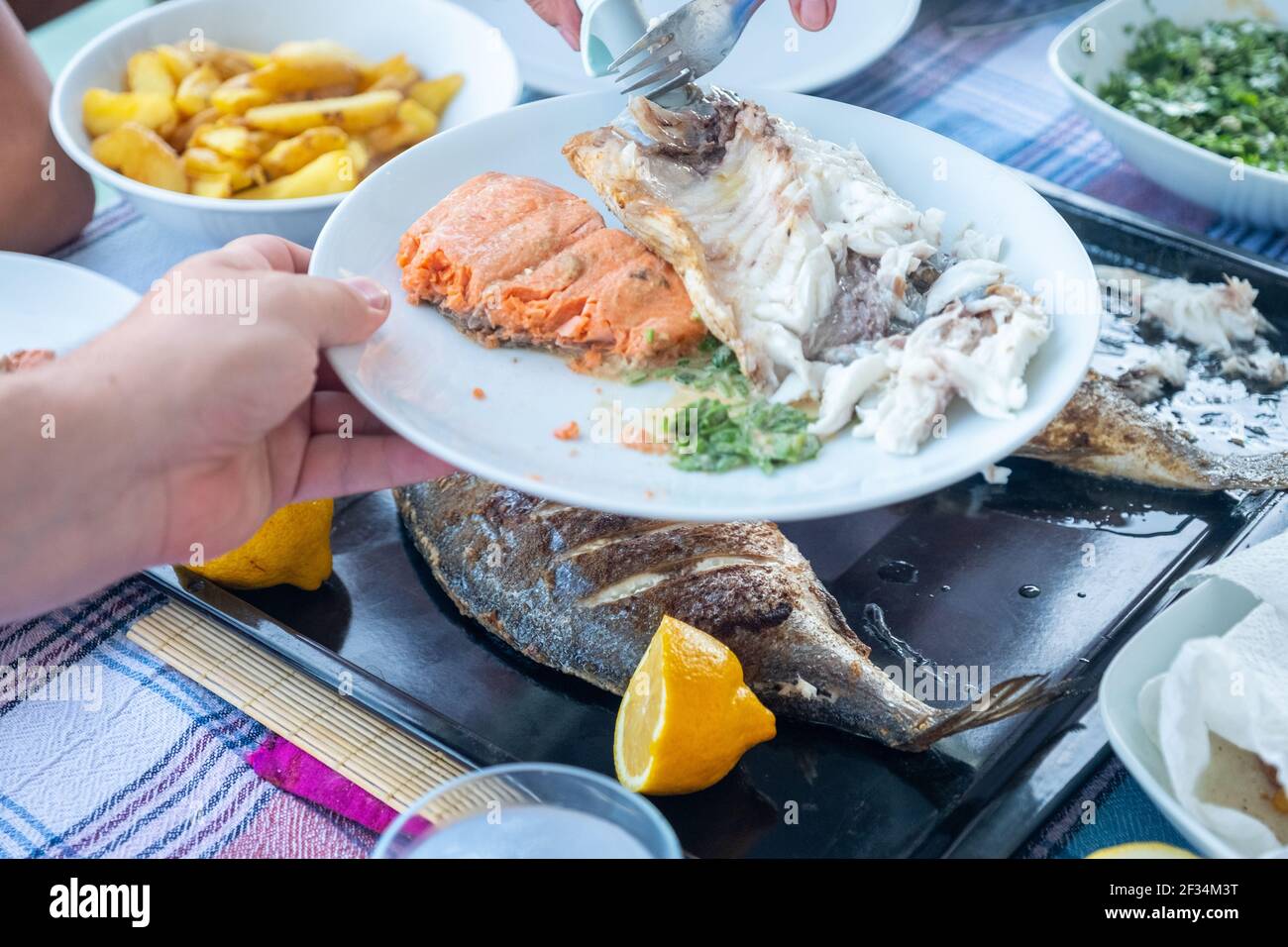 Family gathering to eat fish together Stock Photo - Alamy