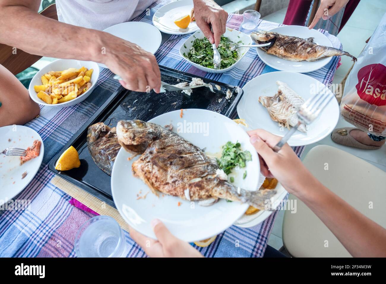 Family gathering to eat fish together Stock Photo - Alamy