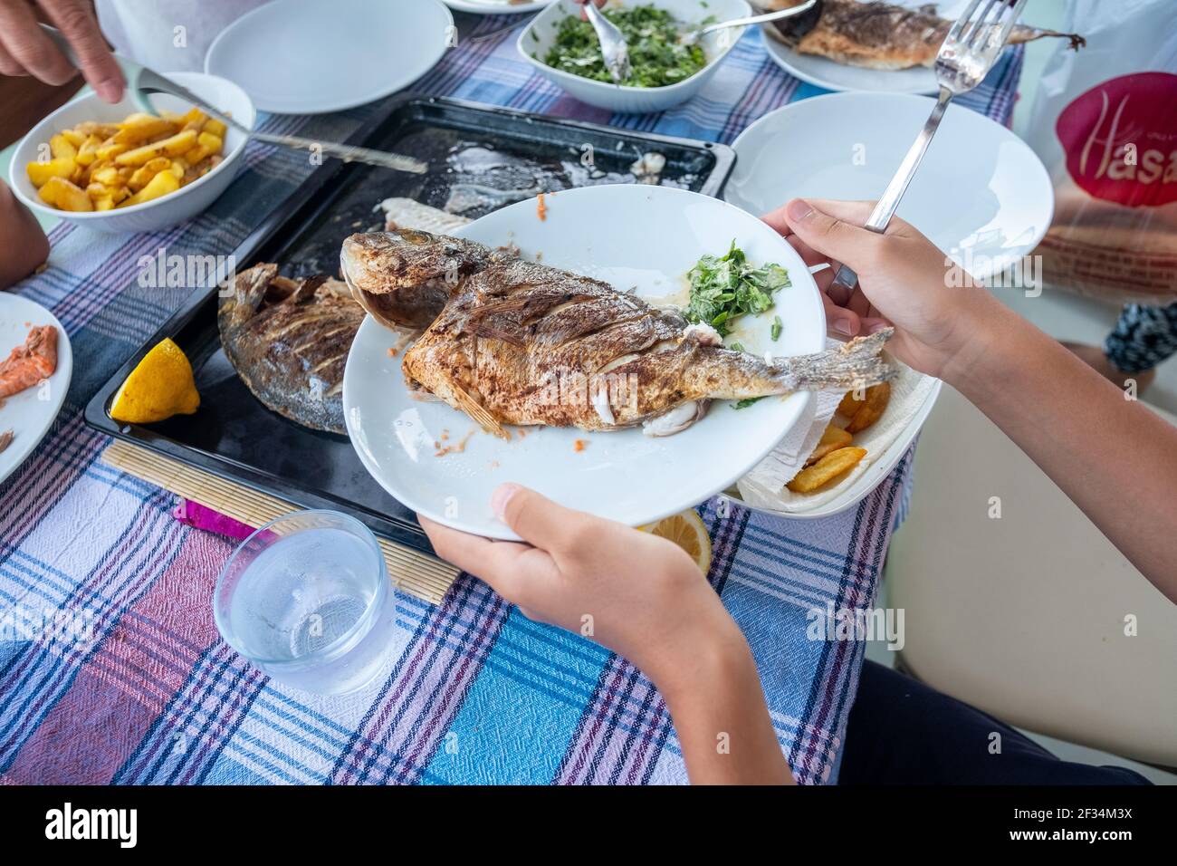 Family gathering to eat fish together Stock Photo - Alamy