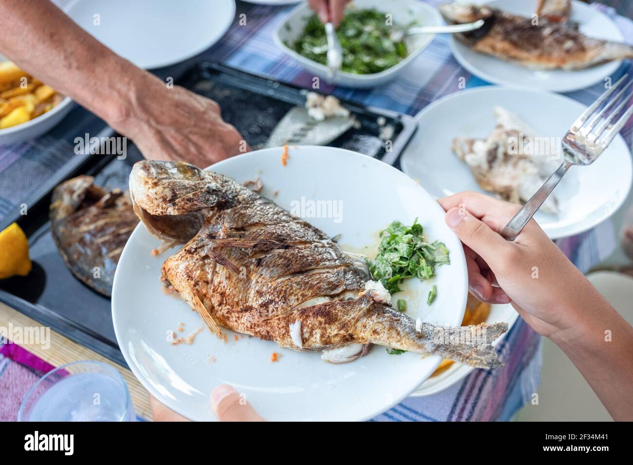 Family gathering to eat fish together Stock Photo - Alamy
