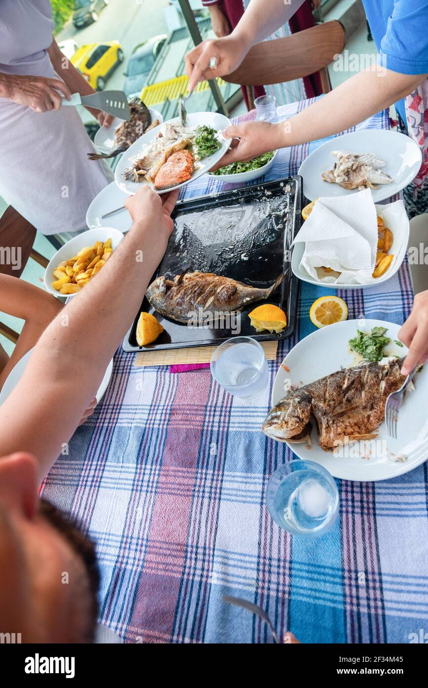 Family gathering to eat fish together Stock Photo - Alamy